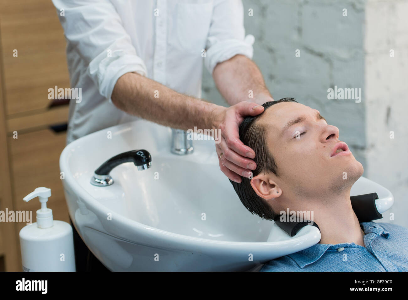 Young man at hairdresser salon getting his hair washed Stock Photo - Alamy