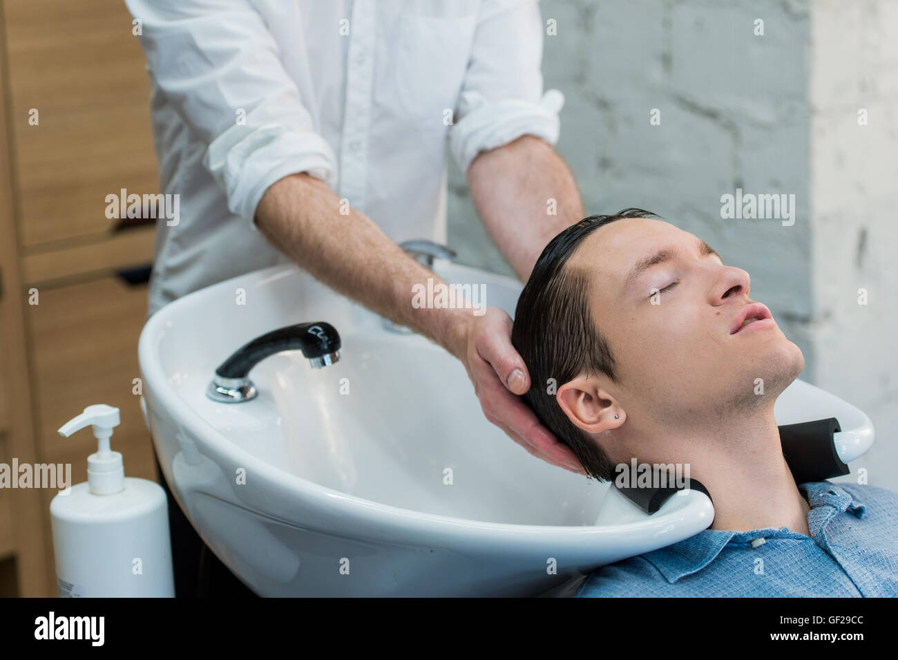 Profile view of a young man getting ready for his hair washed Stock ...