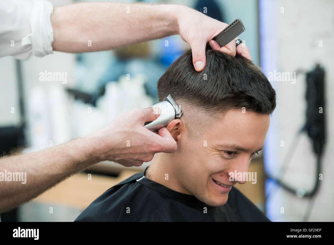 Professional styling. Close up side view of young satisfied man getting ...