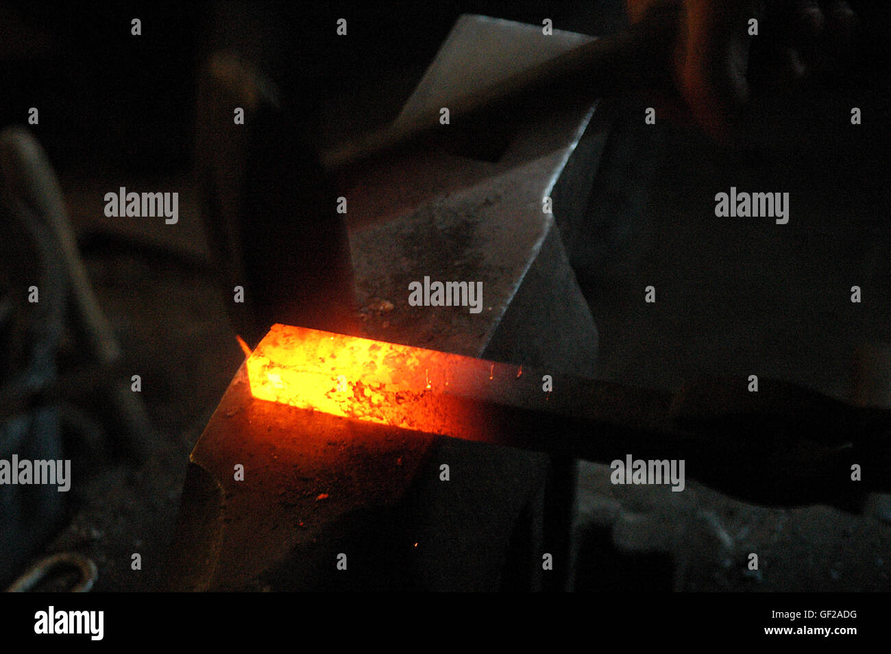 Red hot iron being hammered on an anvil Stock Photo - Alamy