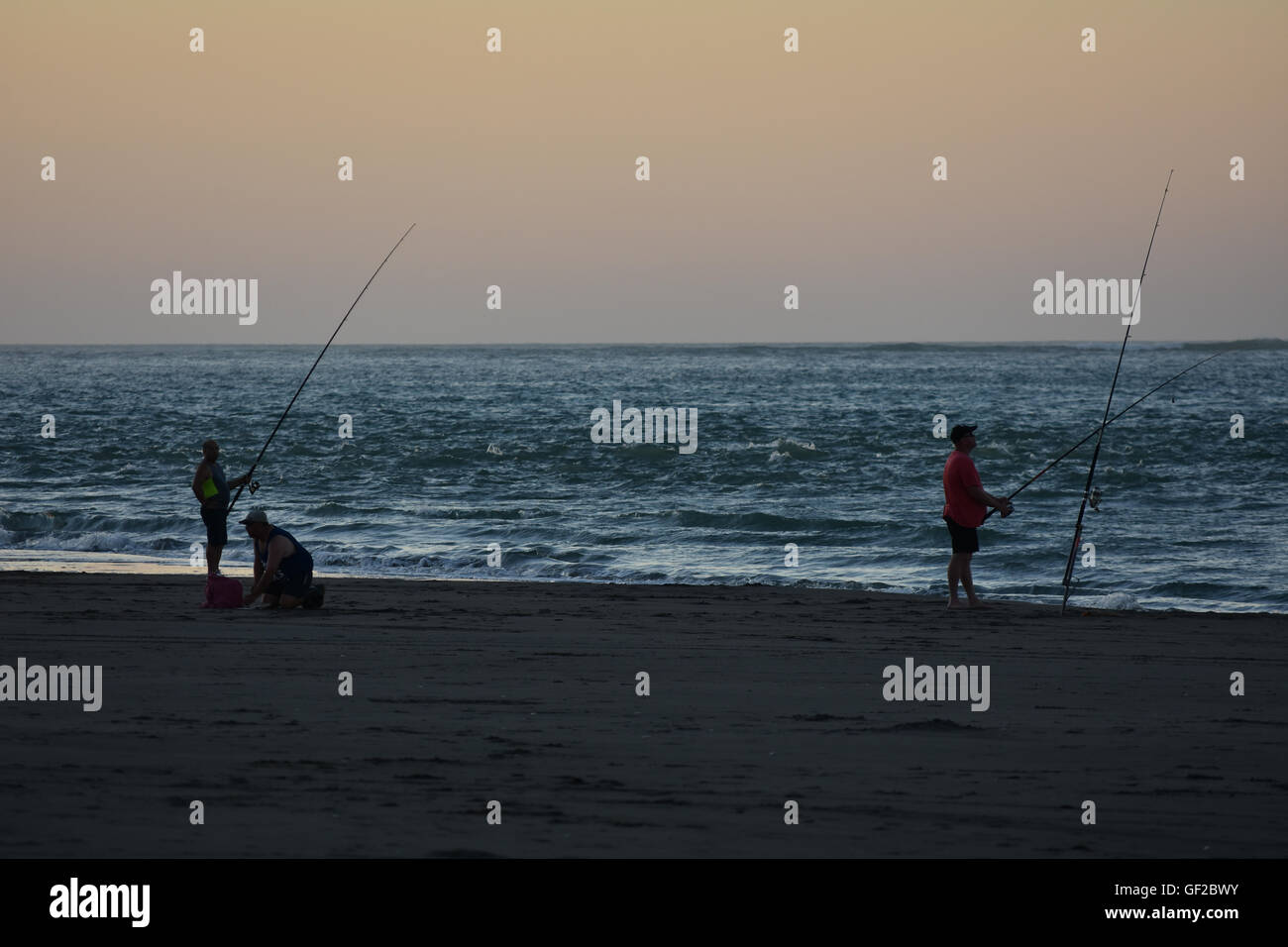 Men fishing at dusk Stock Photo - Alamy