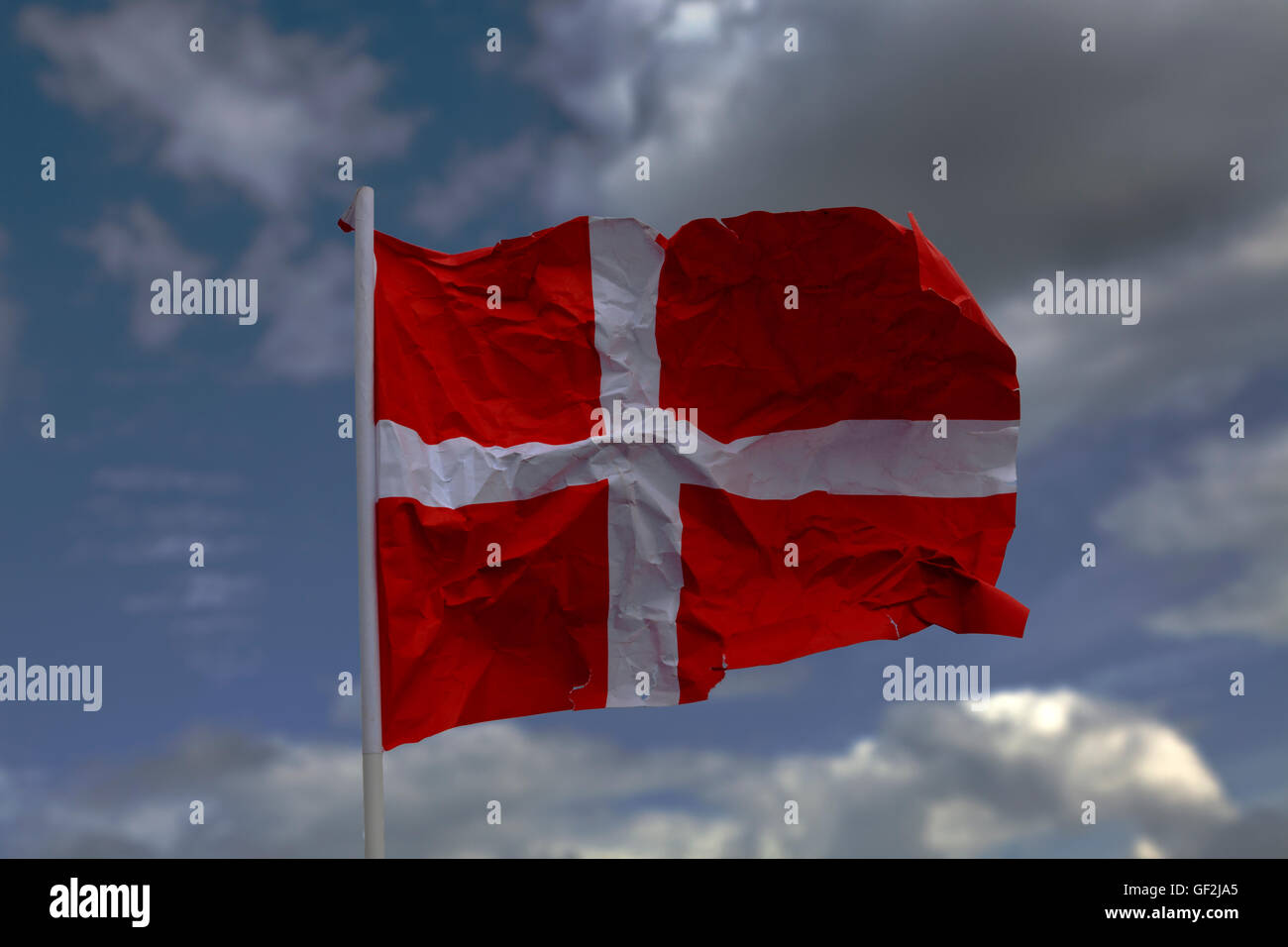 A crumpled, torn and distorted paper Dannebrog flag, the Danish flag ...