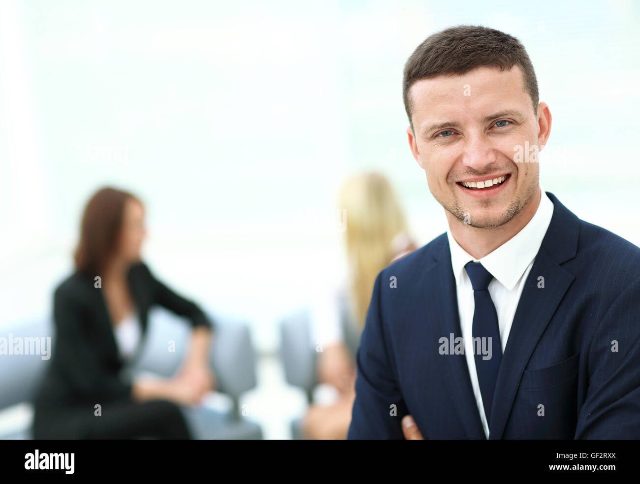 Successful business man standing with his staff in background at Stock ...