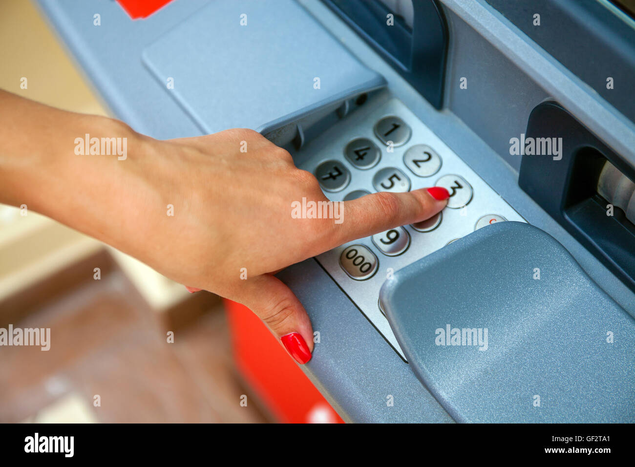 Female arms, ATM - entering pin Stock Photo - Alamy