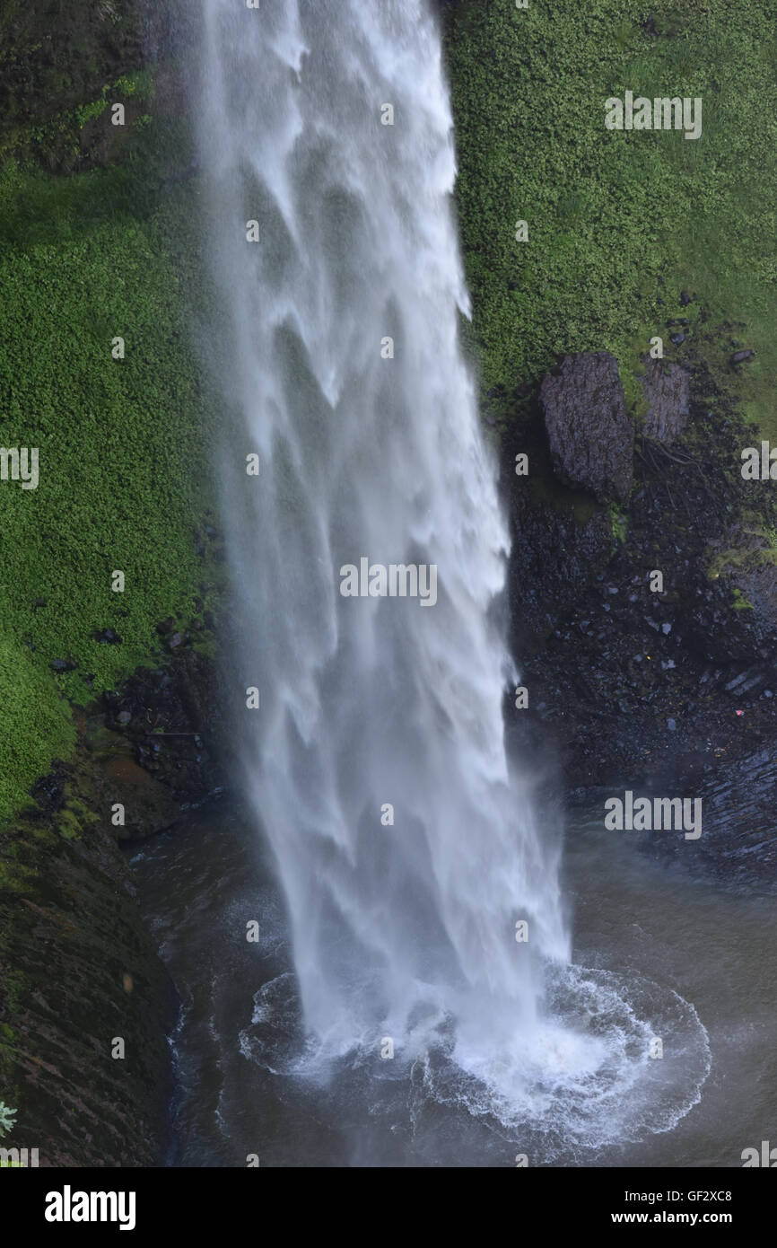 Waterfall pouring water into muddy lake Stock Photo - Alamy