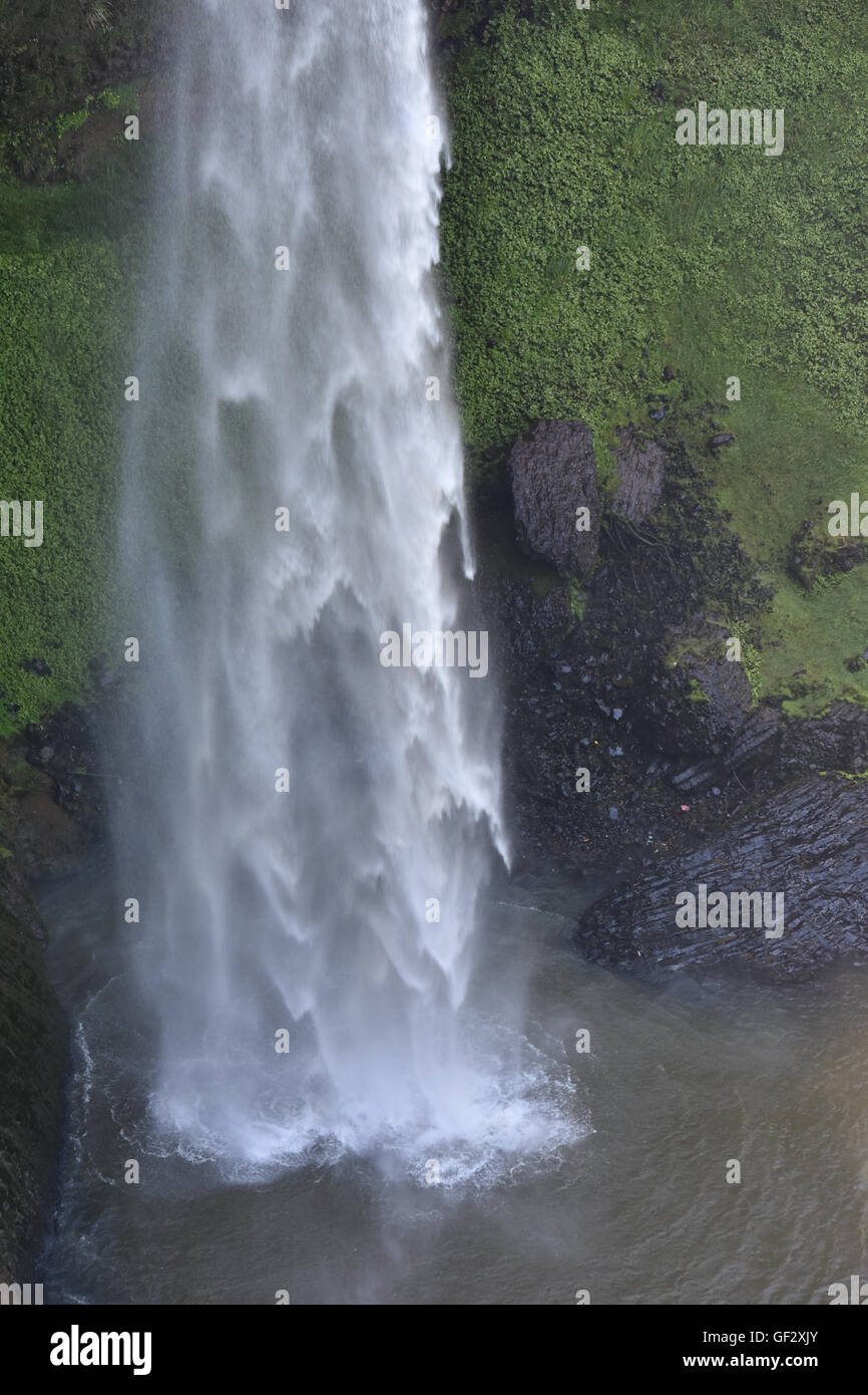 Waterfall pouring water into muddy lake Stock Photo - Alamy