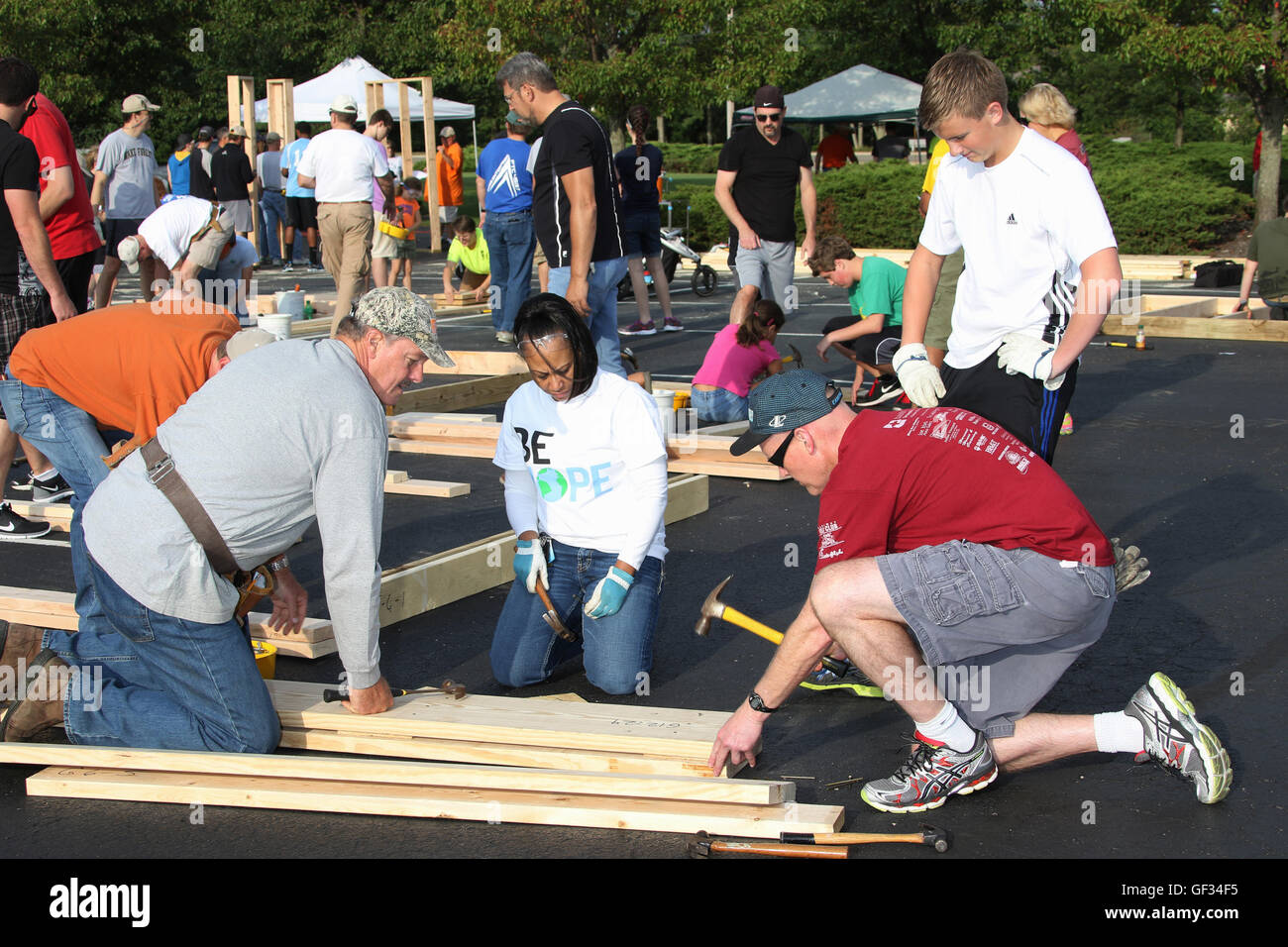 Men and women volunteers building a wall. Habitat For Humanity parking ...