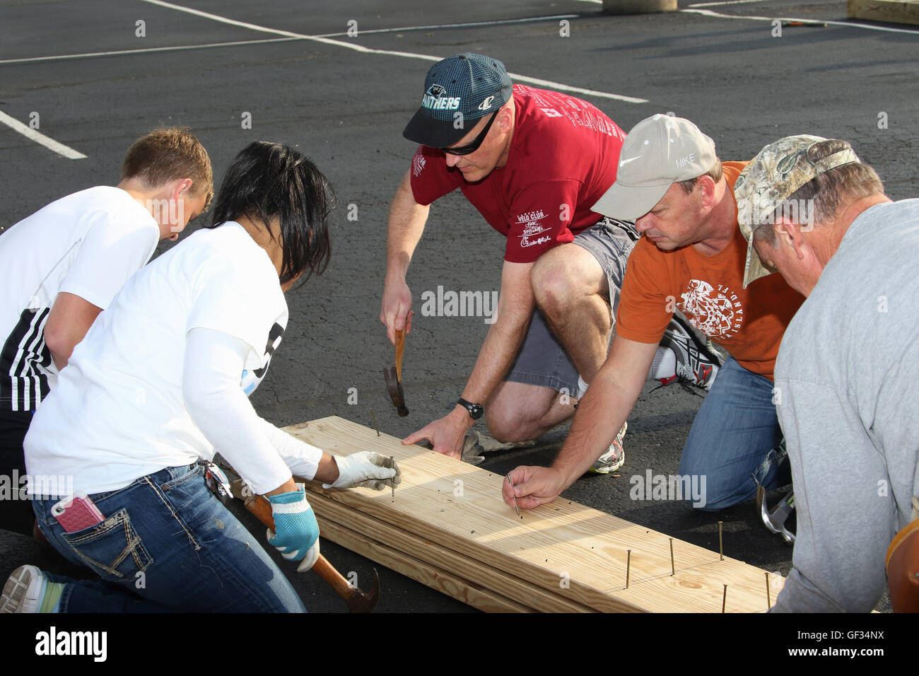 Men and woman volunteers building a wall. Habitat For Humanity parking ...