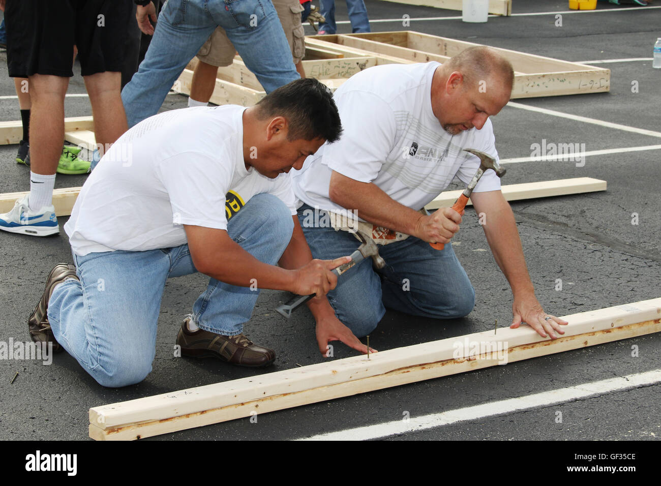 Men volunteers building a wall. Habitat For Humanity parking lot build ...