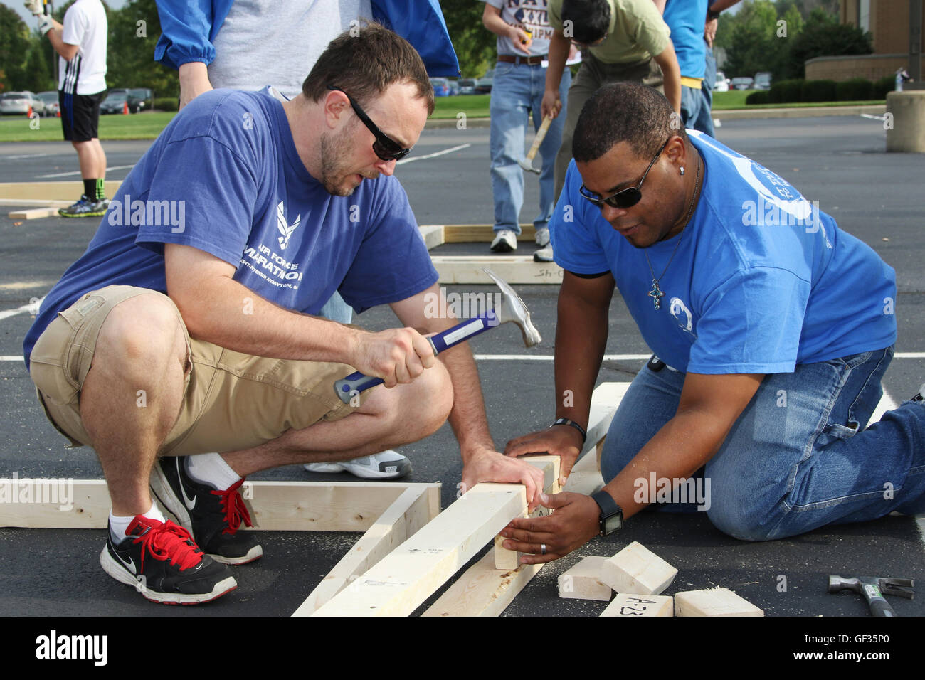Men volunteers building a wall. Habitat For Humanity parking lot build ...