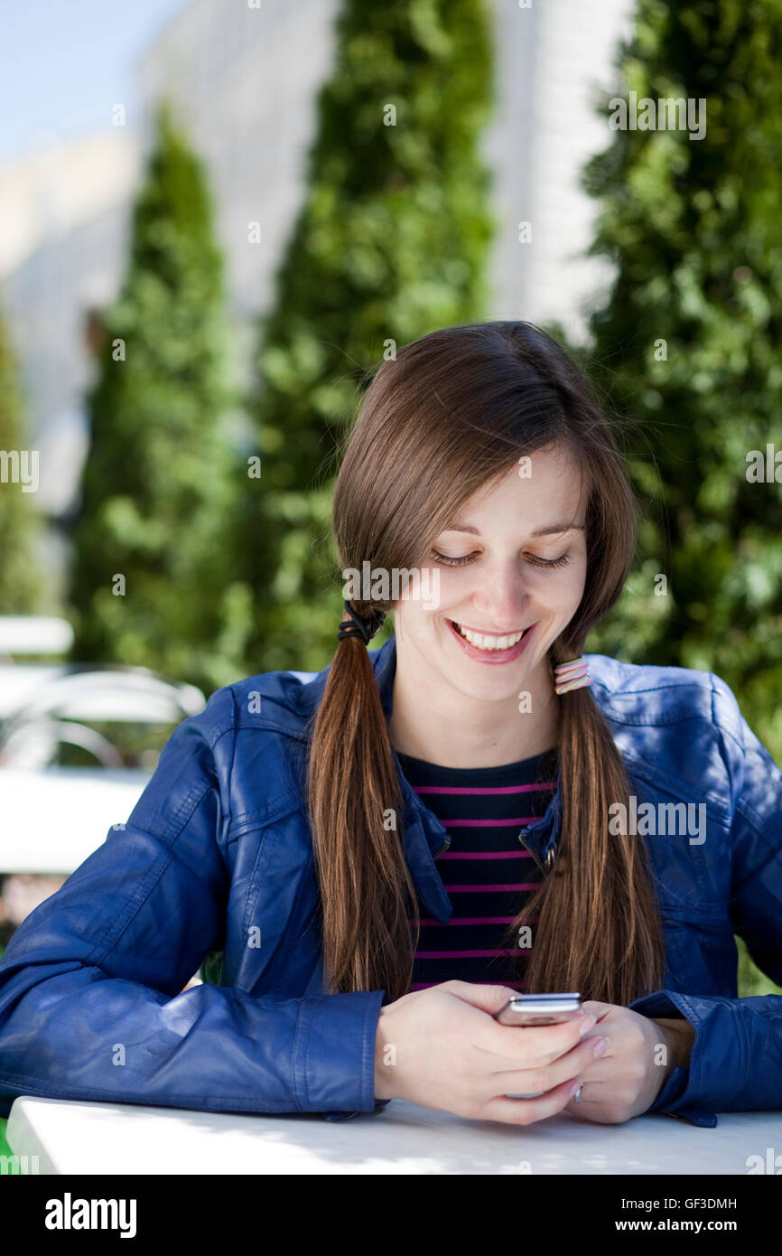 Young woman reading a message on the phone Stock Photo - Alamy