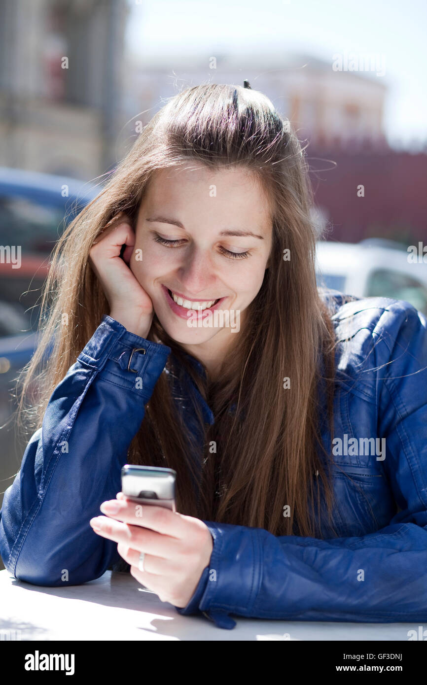 Young woman reading a message on the phone Stock Photo - Alamy