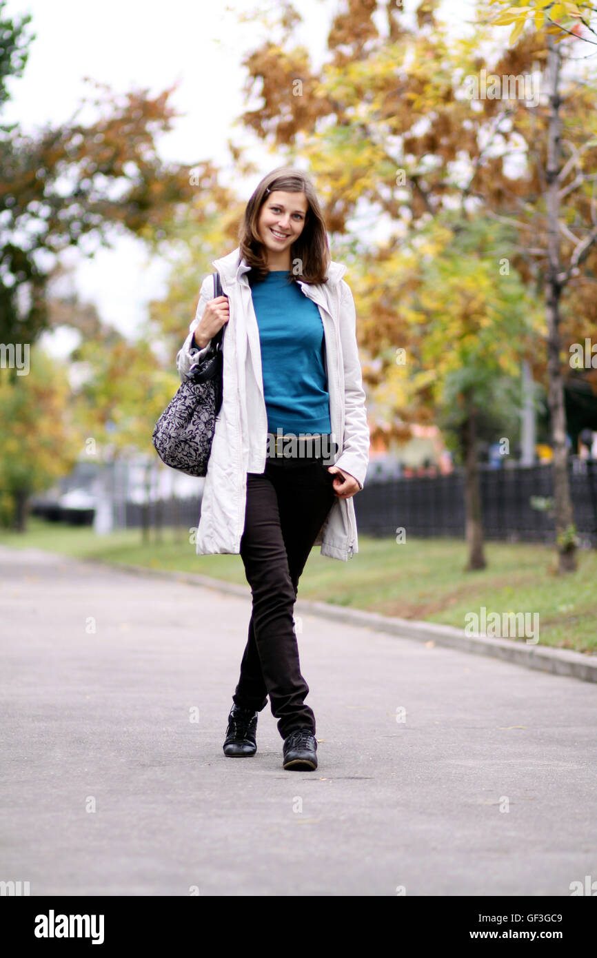 Full length, walking woman in autumn park Stock Photo - Alamy