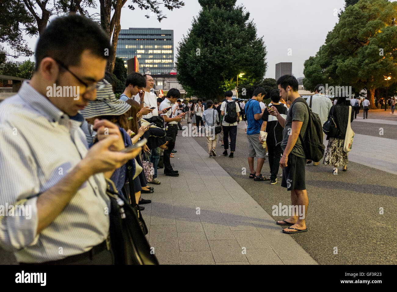 People play Pokemon Go on their smartphones in Ueno Park in Tokyo ...