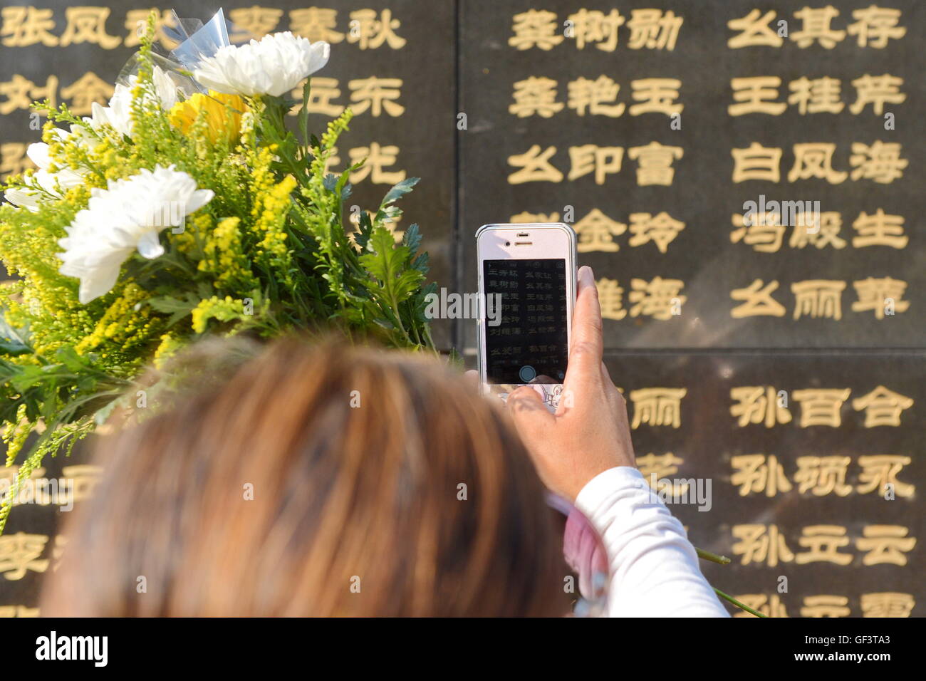 Tangshan, China's Hebei Province. 28th July, 2016. A woman takes photos ...