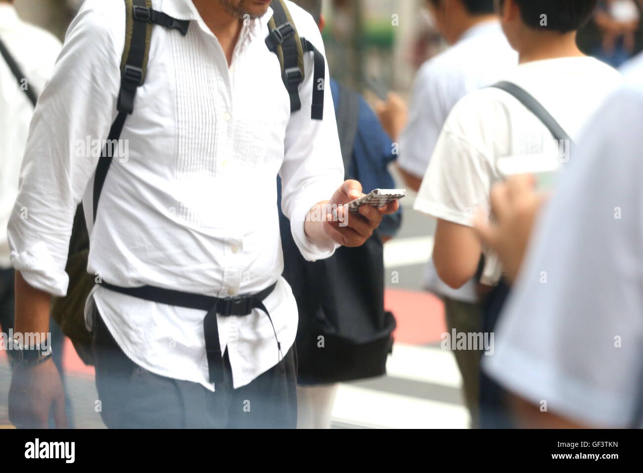 People look at their smartphones in Tokyo, Japan on July 27, 2016 ...