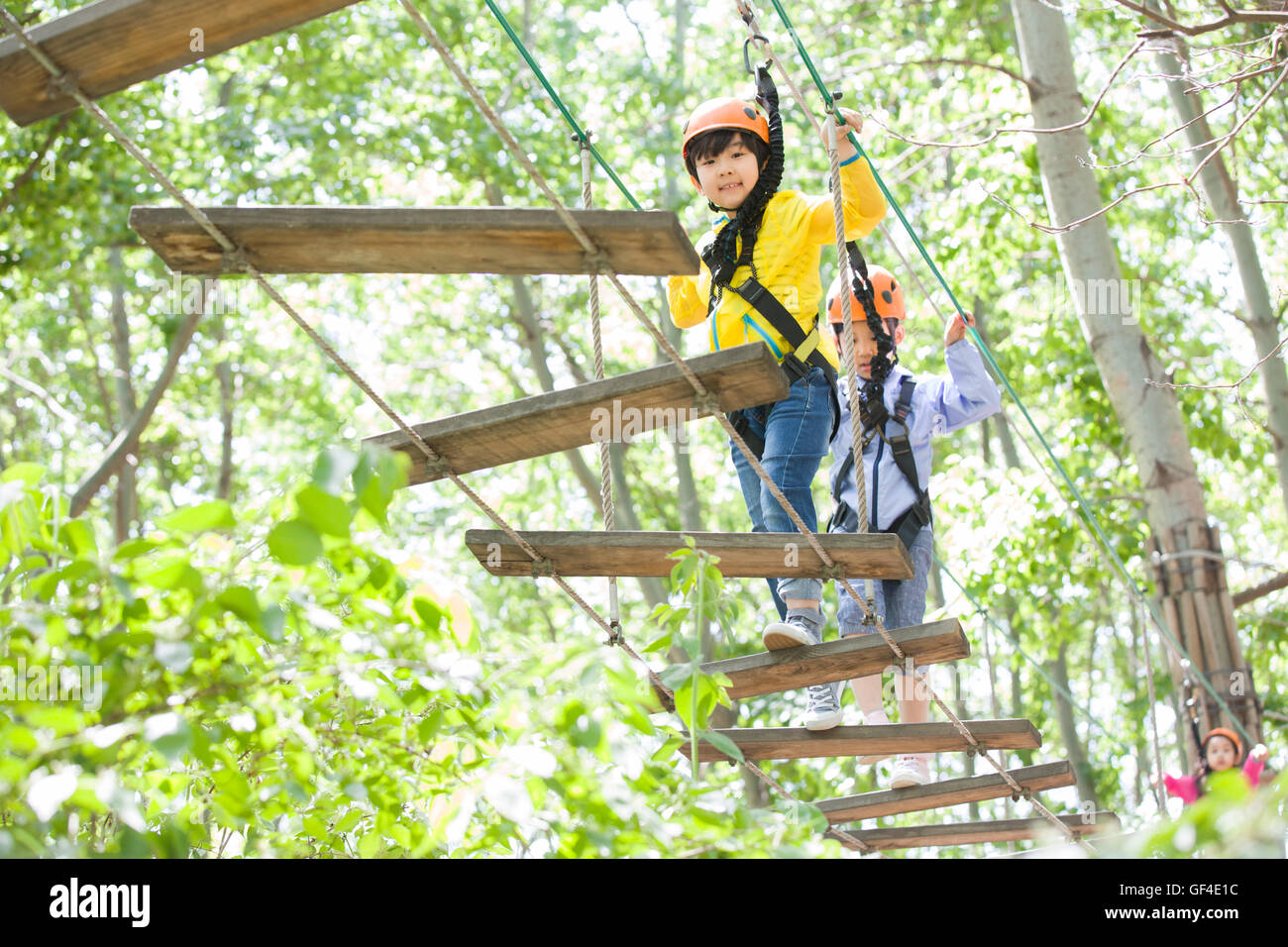 Happy Chinese children playing in tree top adventure park Stock Photo ...