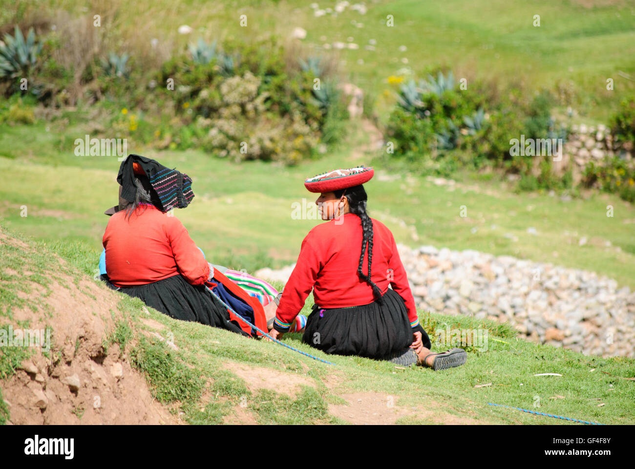 Two Andean Indian women in their traditional costume sitting on the ...