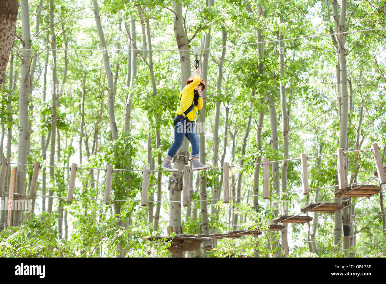 Little Chinese boy playing in tree top adventure park Stock Photo - Alamy
