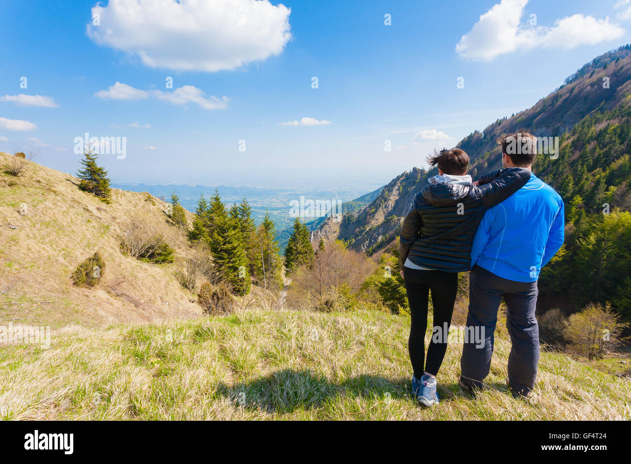 Young couple on top of mountain looking at the horizon. Mountain ...