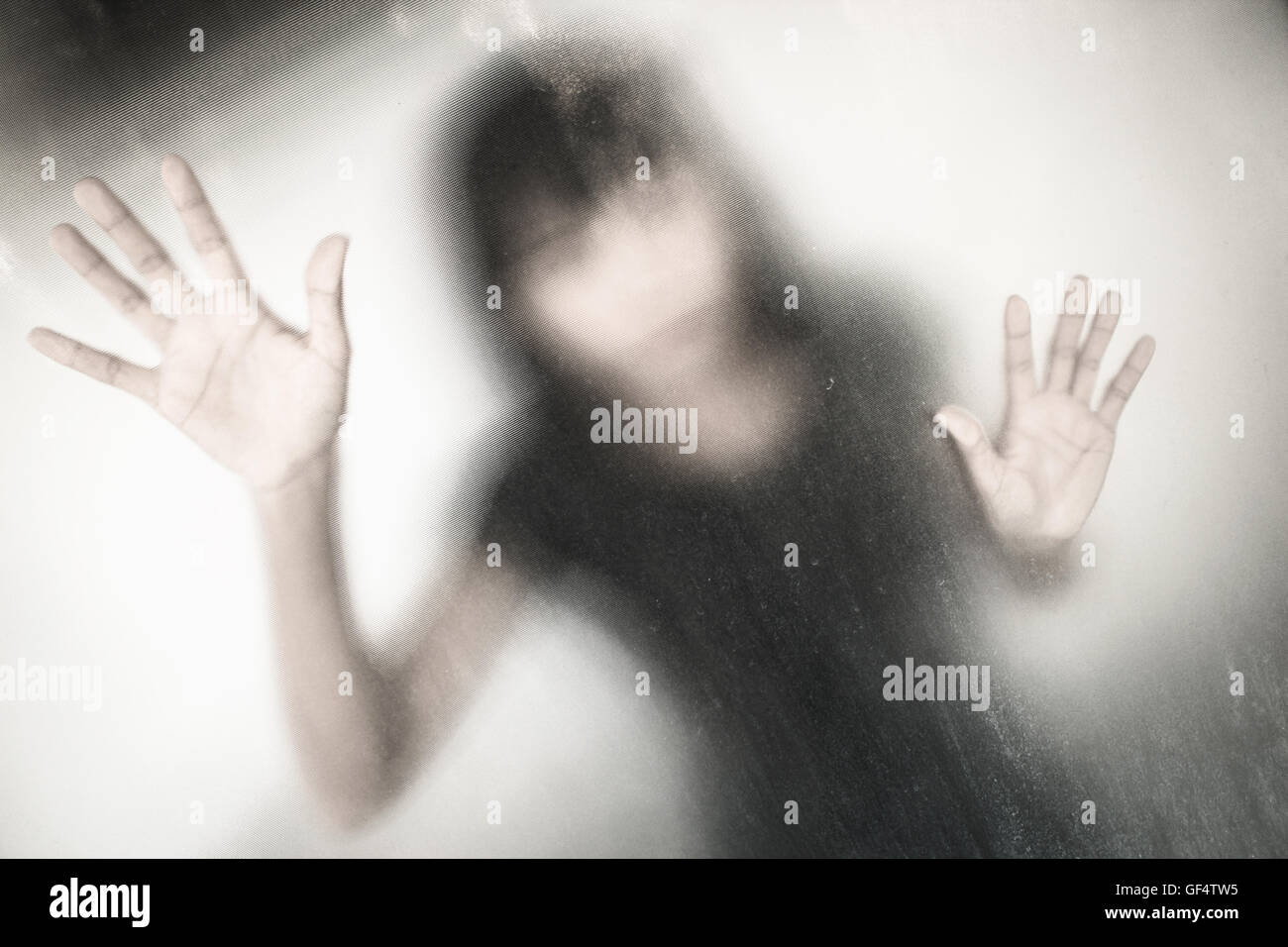 Woman behind stained or dirty window glass,Scary background for book ...