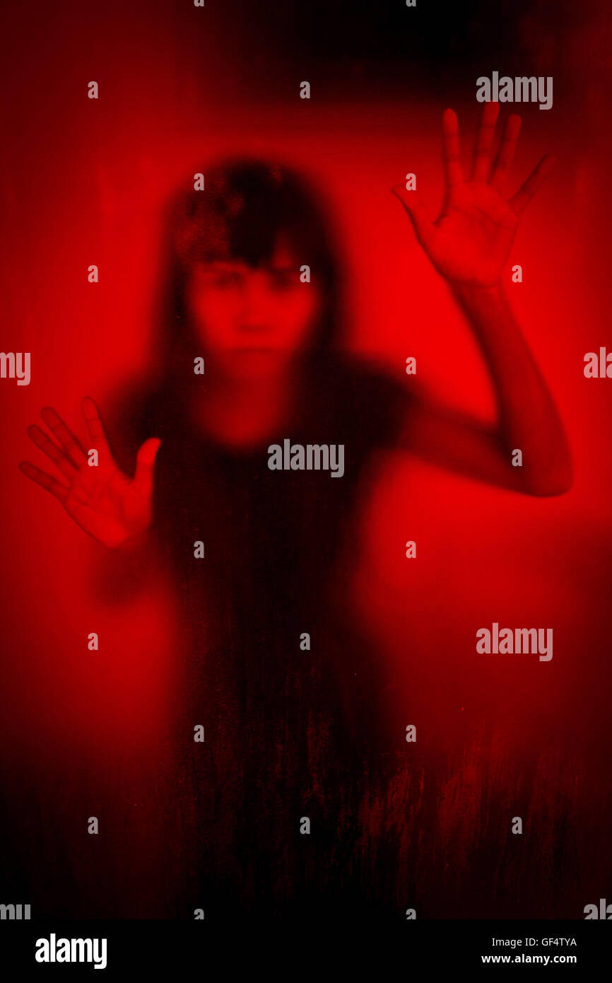 Woman behind stained or dirty window glass,Scary background for book ...