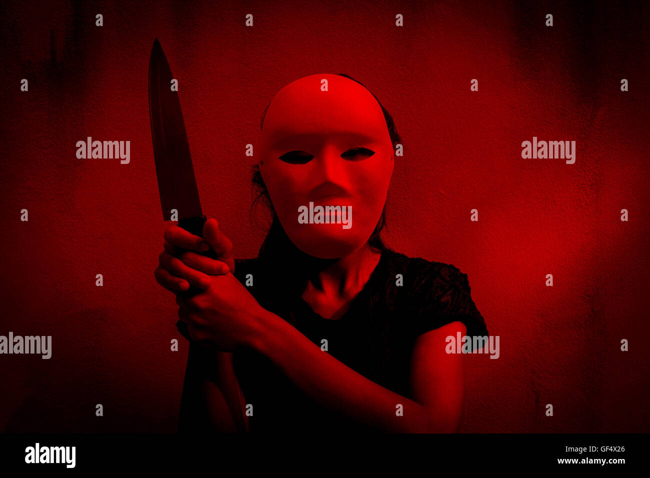 Mysterious woman in black dress wearing white mask holding knife ,Scary ...
