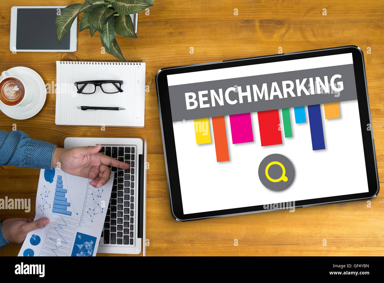 BENCHMARKING Businessman working at office desk and using computer and ...