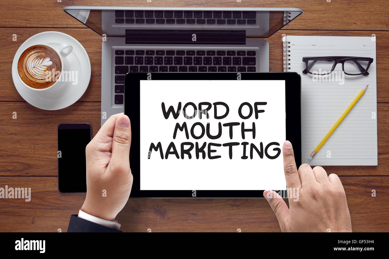 WORD OF MOUTH MARKETING, on the tablet pc screen held by businessman ...