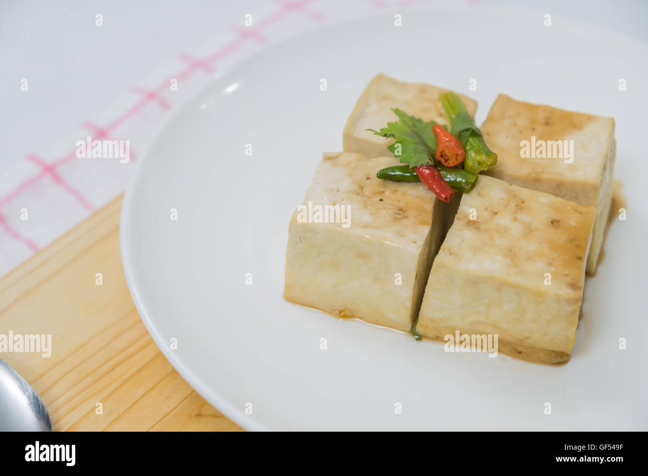 Block of Tofu and chopping board with chili and ginger Stock Photo - Alamy
