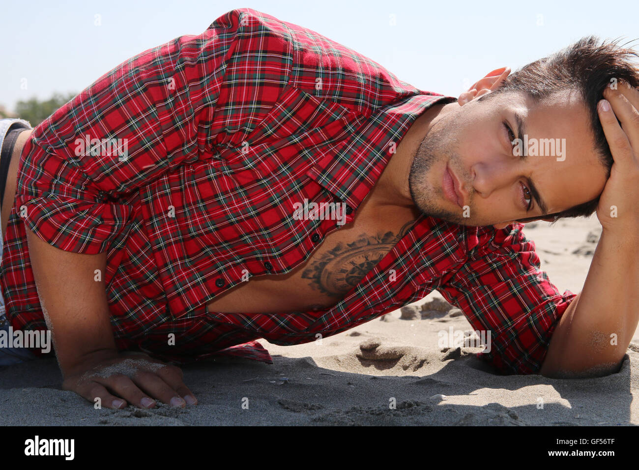 Handsome guy lying on the sand Stock Photo - Alamy