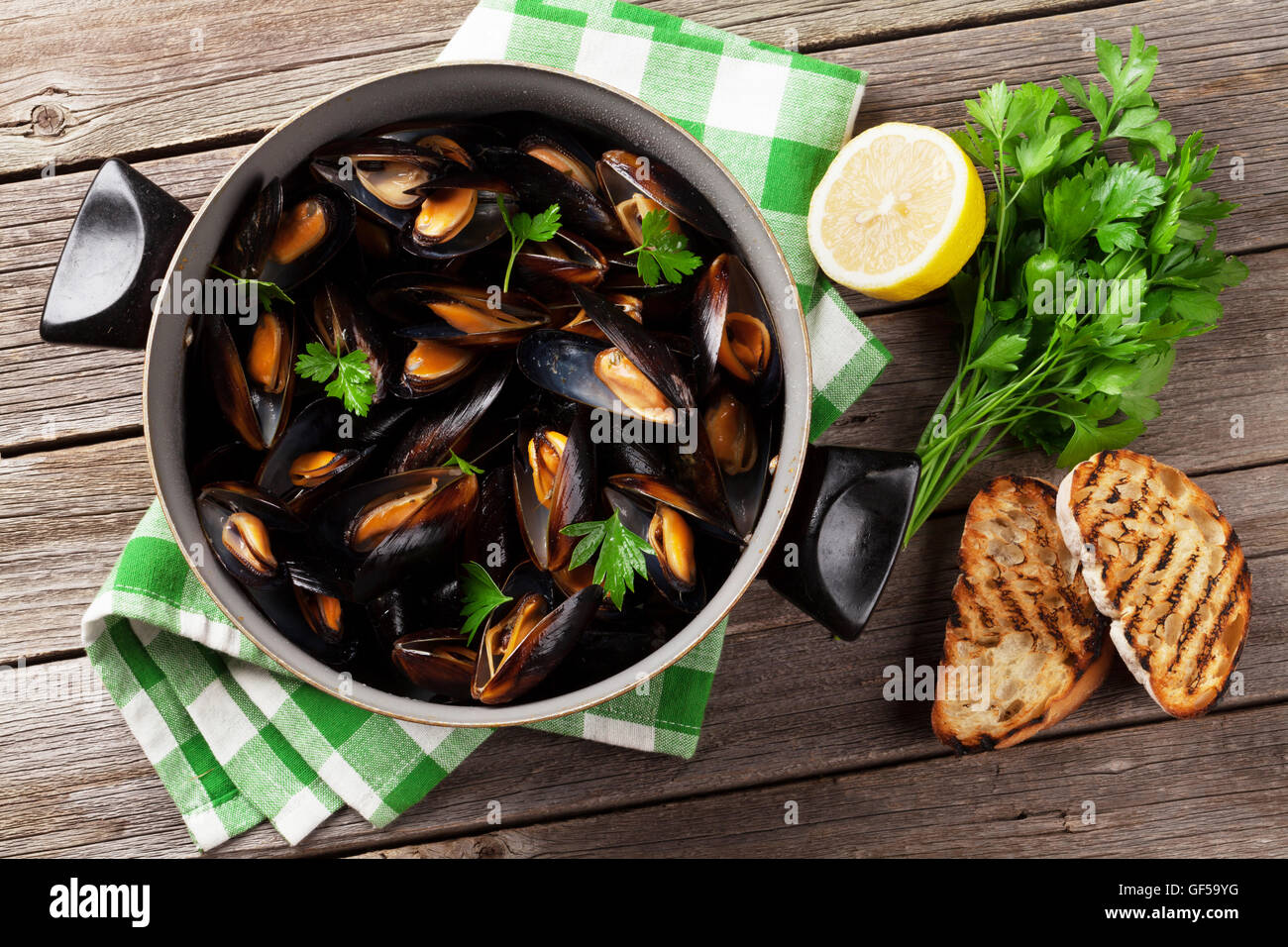 Mussels and bread toasts on wooden table. Top view Stock Photo - Alamy