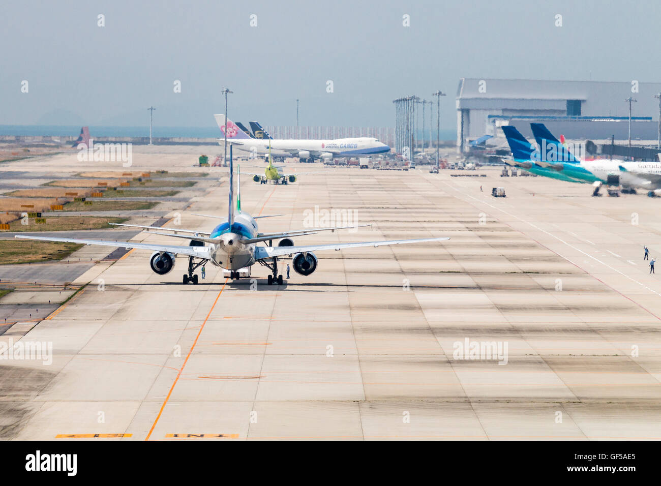 Japan, Kansai airport, KIX. Two airplanes taxing along runway in ...