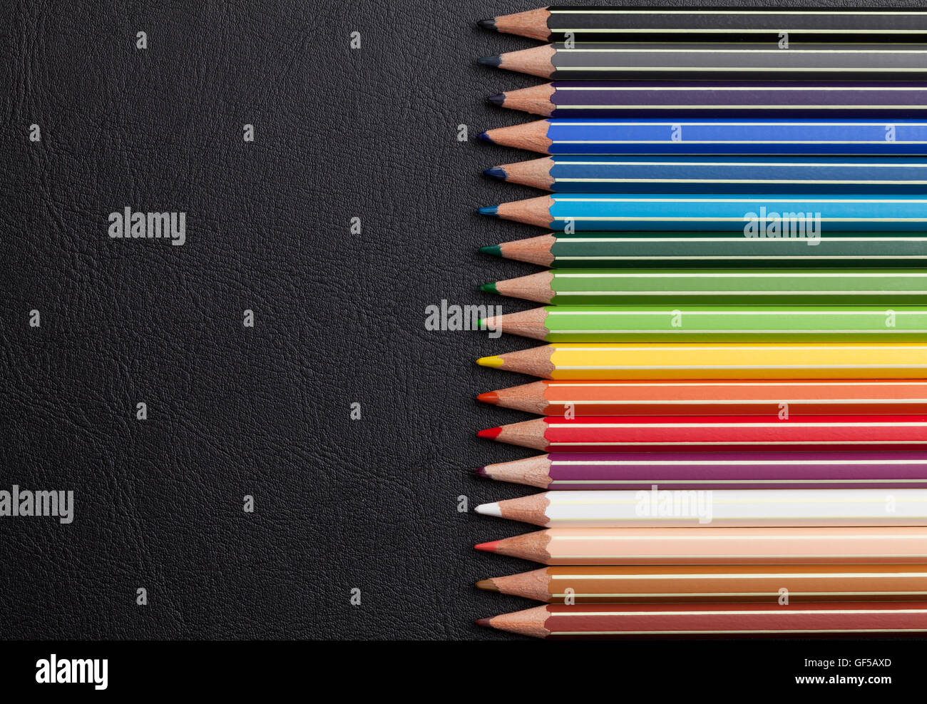 Colorful pencils over leather desk table. Top view with copy space ...