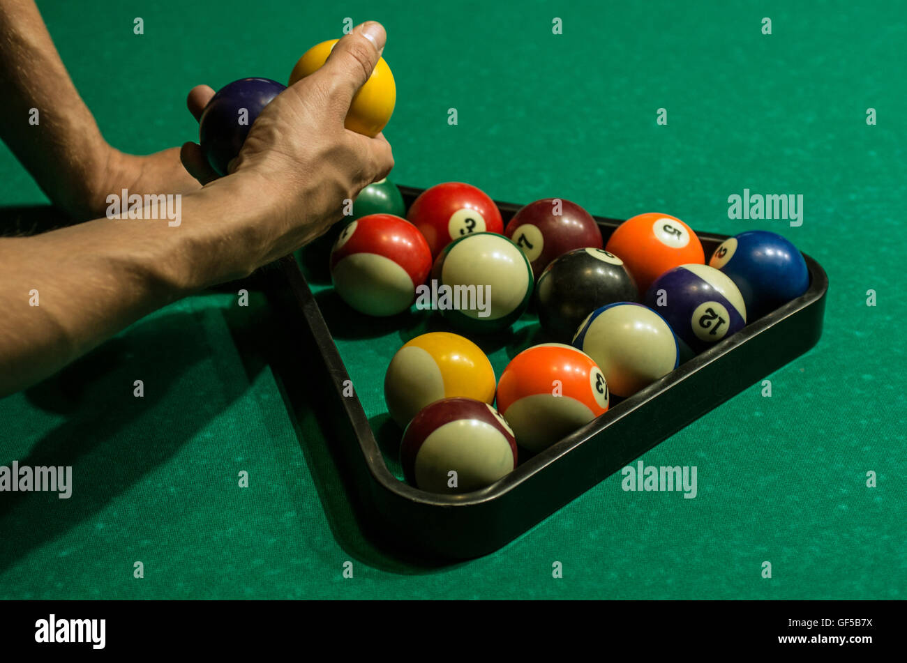 A pool player getting balls in triangle ready for a game Stock Photo ...