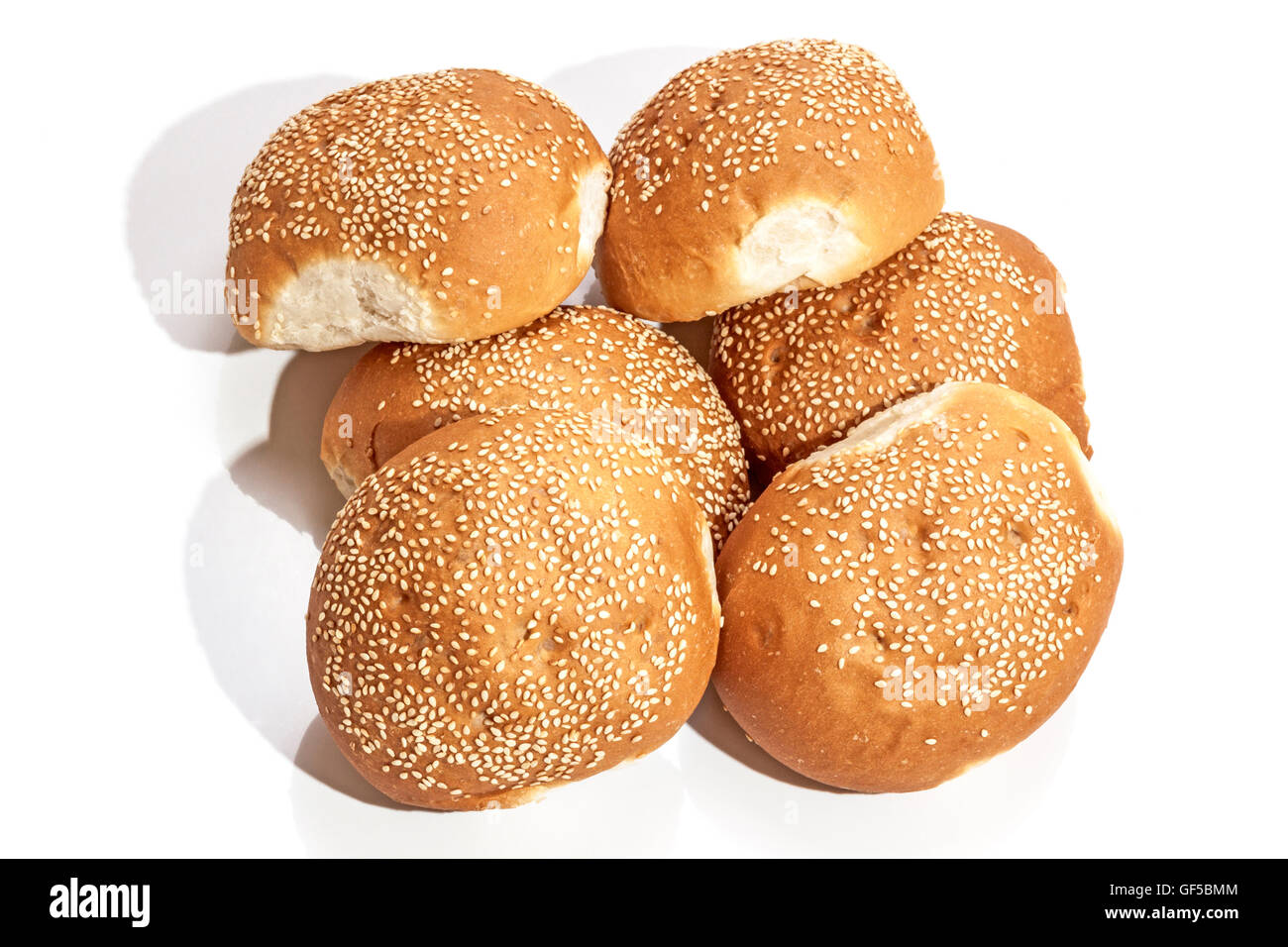 Freshly baked Stack of six golden crisp bread rolls covered with sesame ...