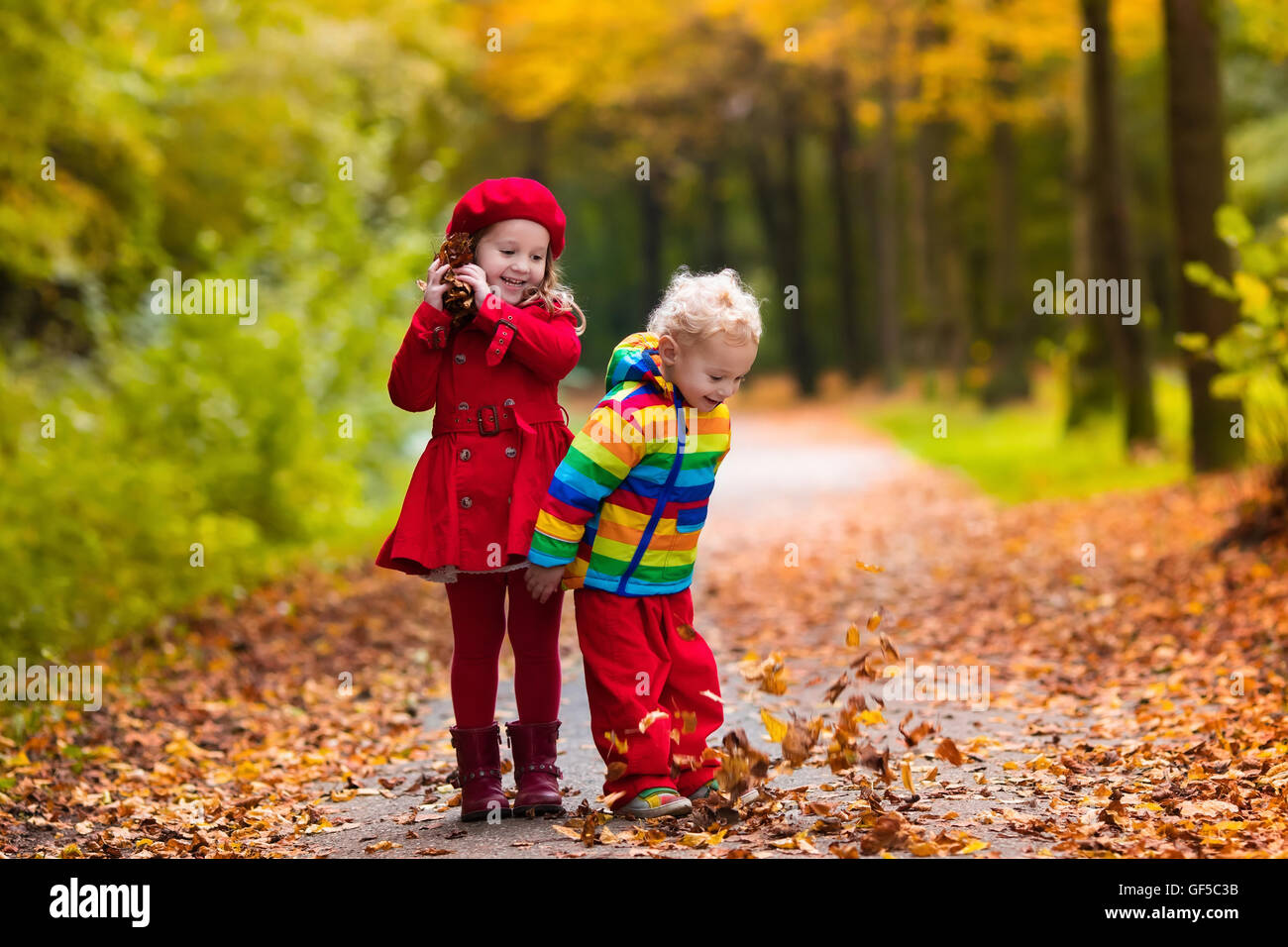 Kids playing in autumn park. Children play outdoors on a sunny fall day ...