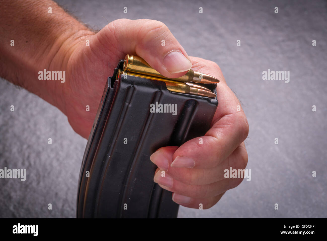 Man's hand Loading Ammunition in Magazine .223/556 on Slate Surface ...