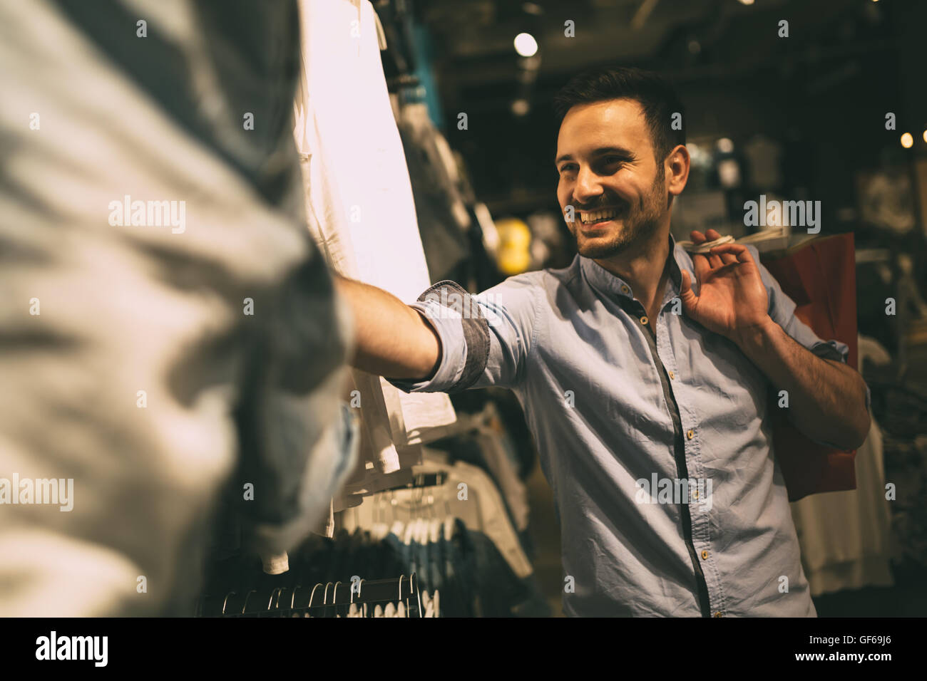 Handsome man buying new clothes Stock Photo - Alamy