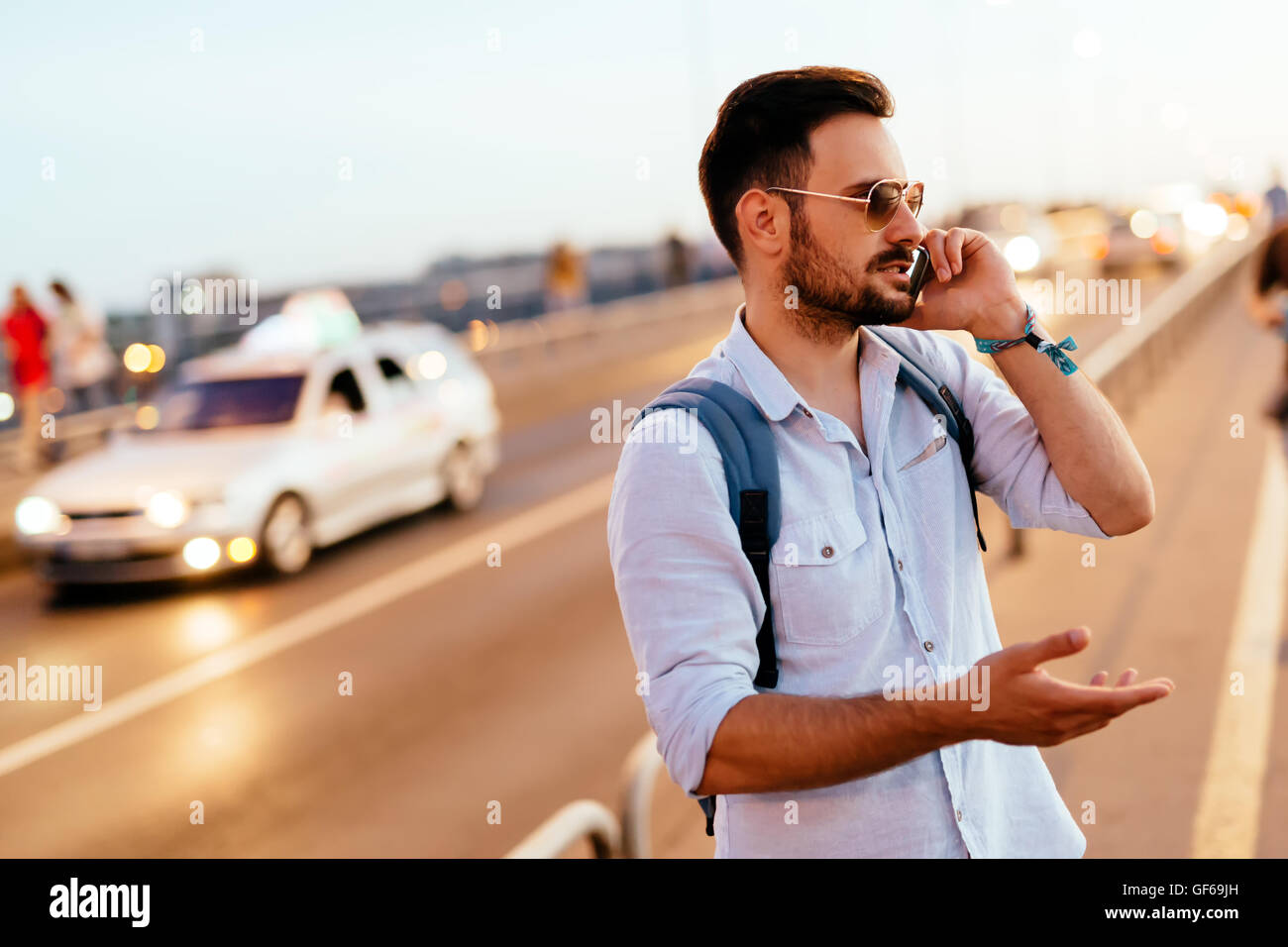 Handsome man waiting for and calling taxi Stock Photo - Alamy