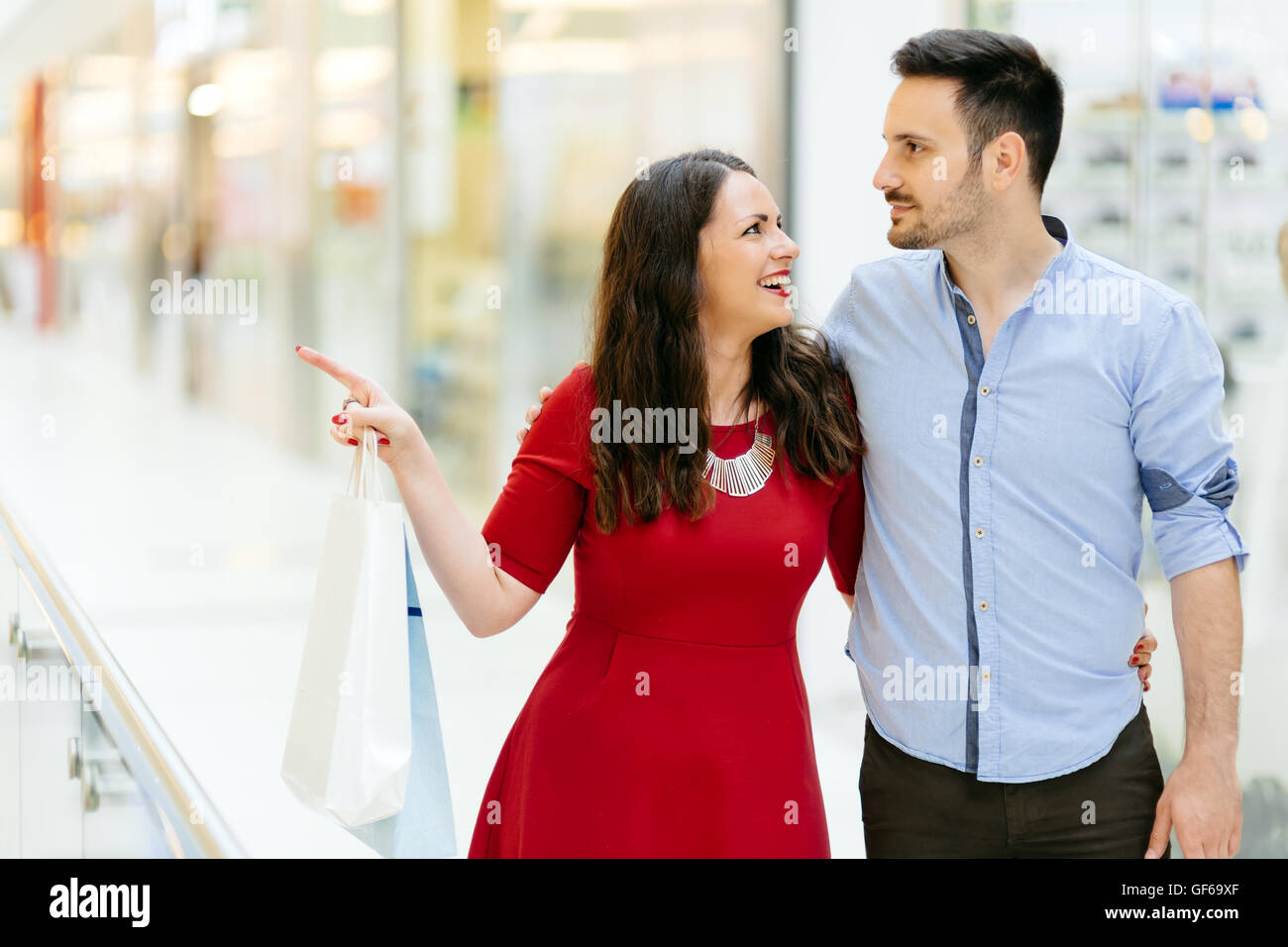 Happy shopper couple buying clothes in shopping center Stock Photo - Alamy