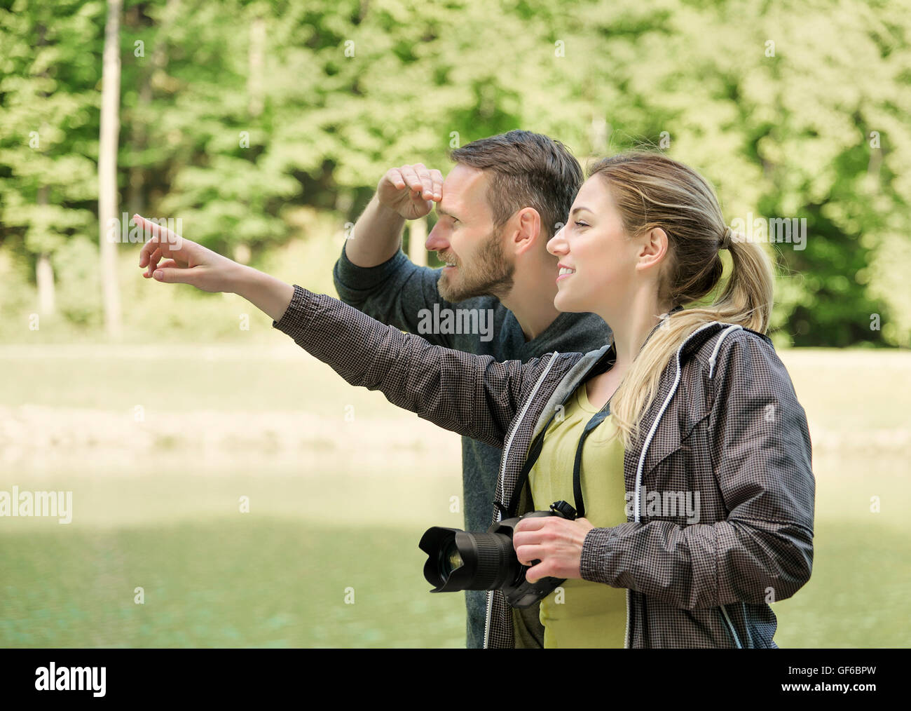 Happy couple tourists in nature point to interesting objects Stock ...