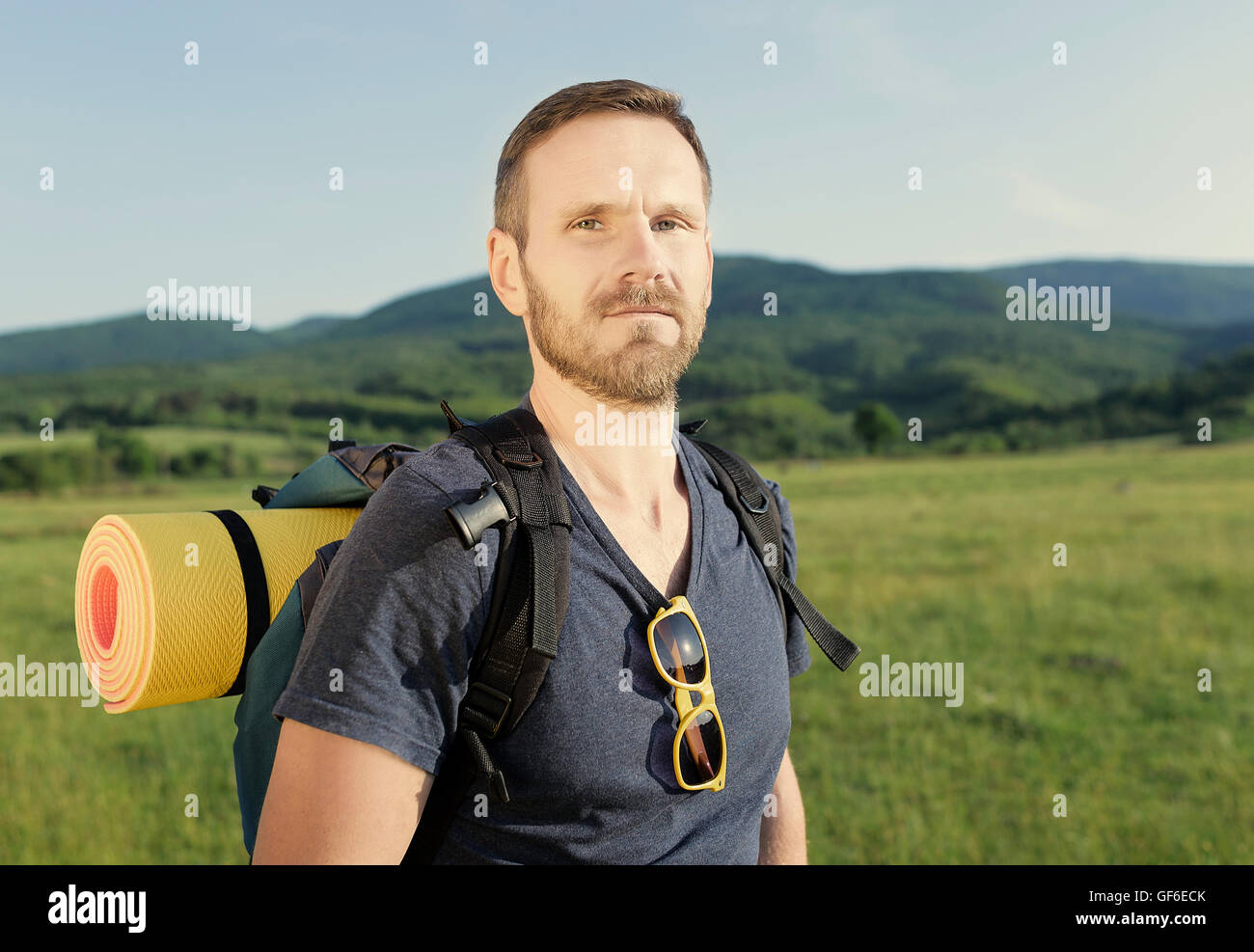 Attractive male hiker on hillside on sunset Stock Photo - Alamy