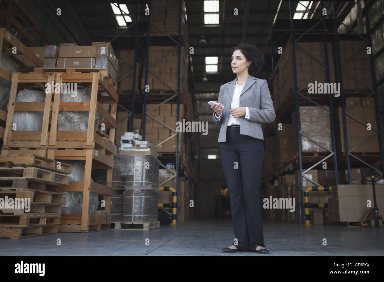 Woman standing in warehouse Stock Photo - Alamy
