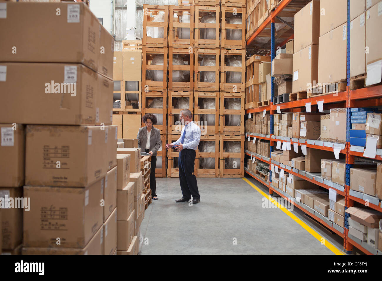 Two people standing in warehouse Stock Photo - Alamy