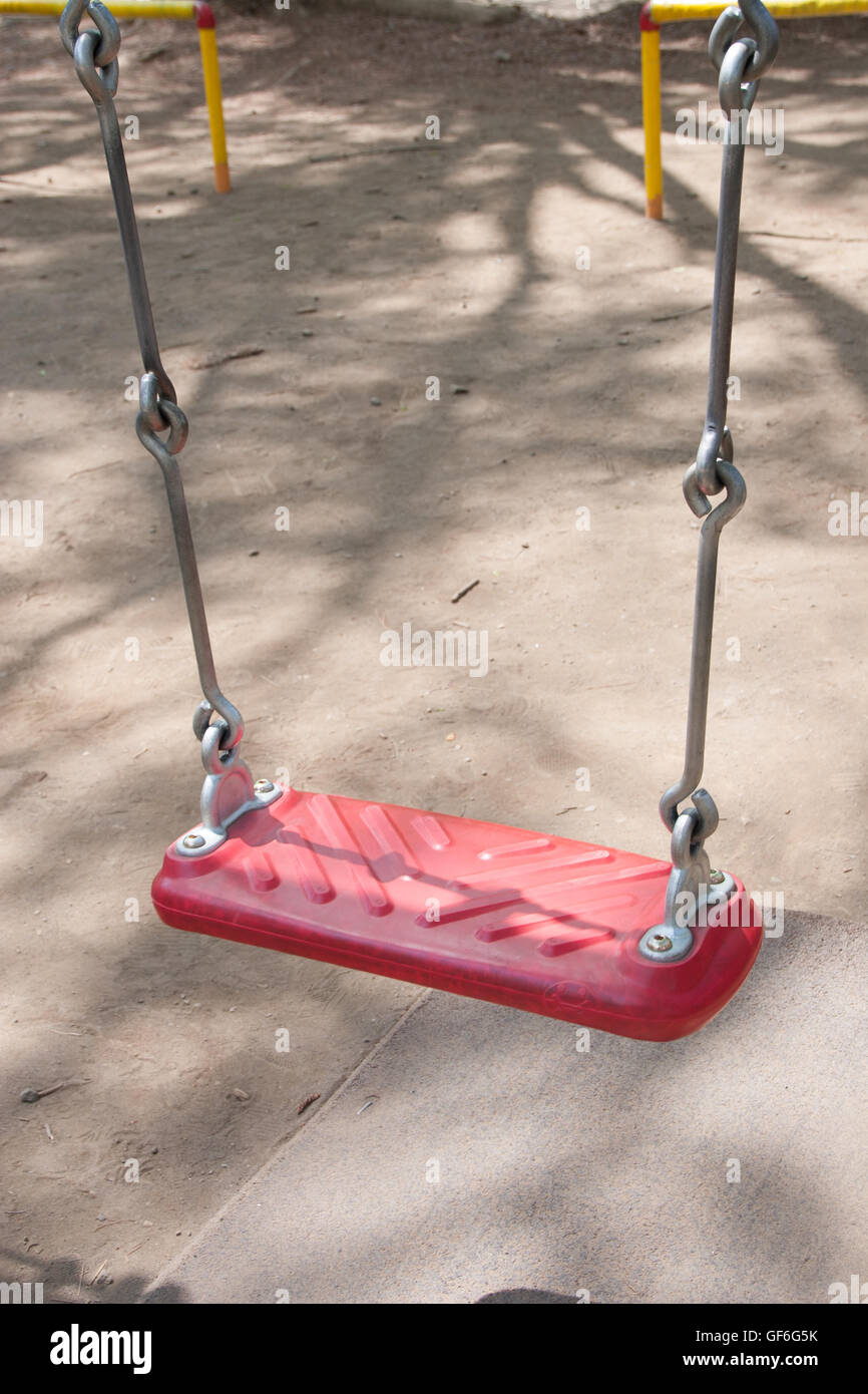 Red swing in the park Stock Photo - Alamy