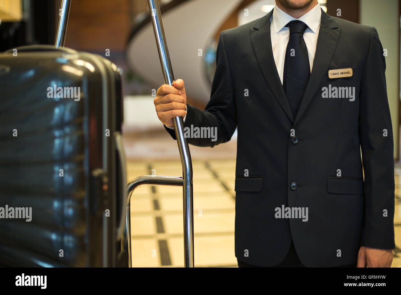 Receptionist carrying luggage trolley Stock Photo - Alamy