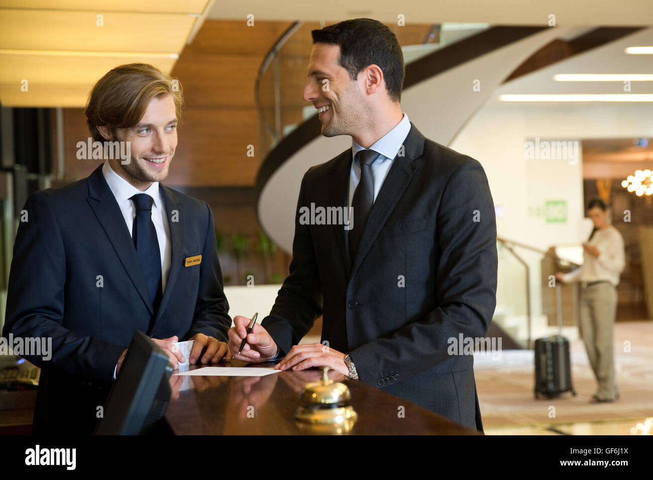 Businessman checking out in hotel reception Stock Photo - Alamy
