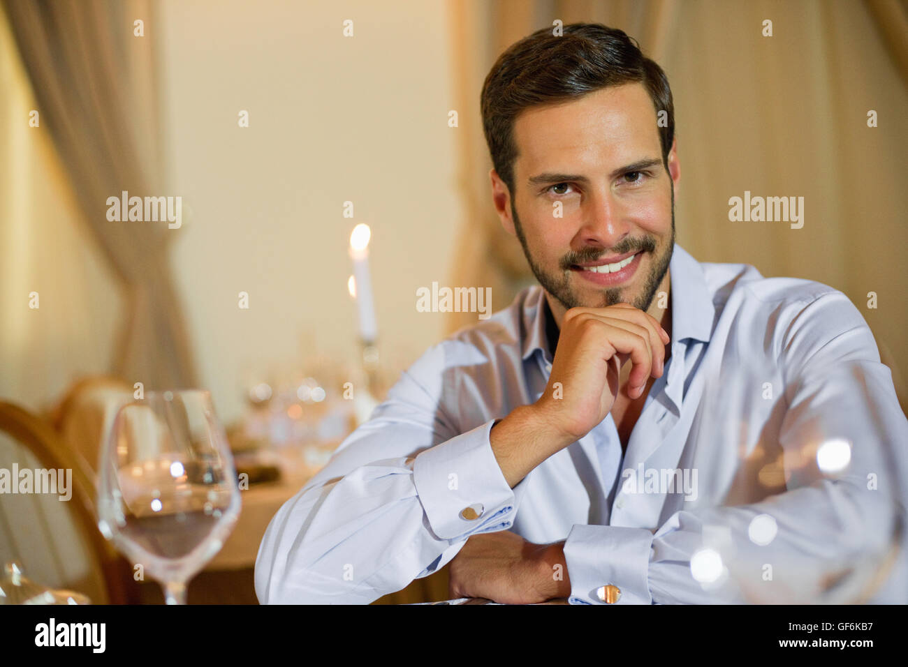 Portrait of man sitting in restaurant, smiling Stock Photo - Alamy