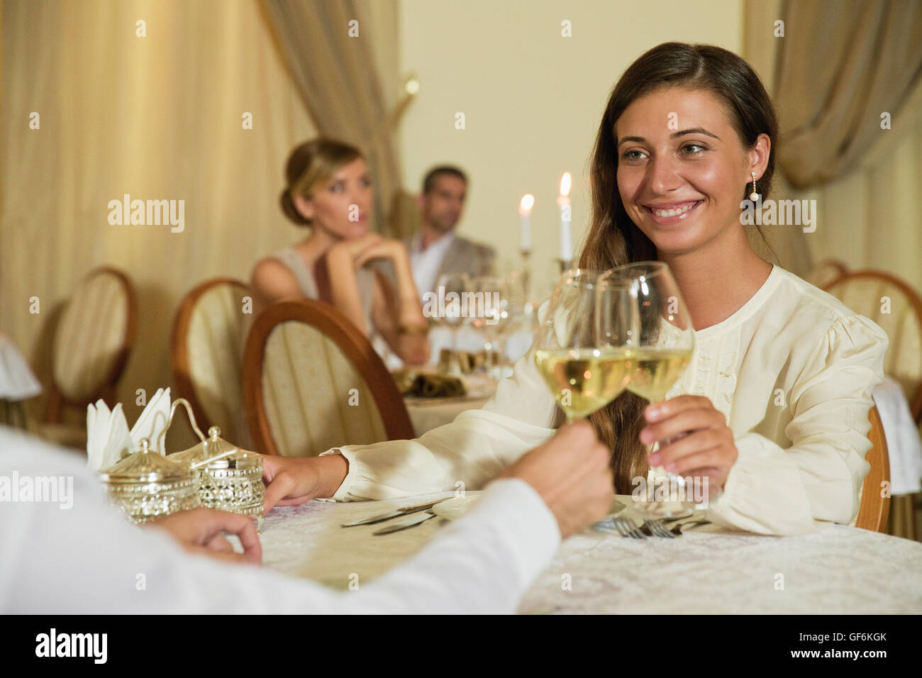 Woman sitting in restaurant with people in background Stock Photo - Alamy